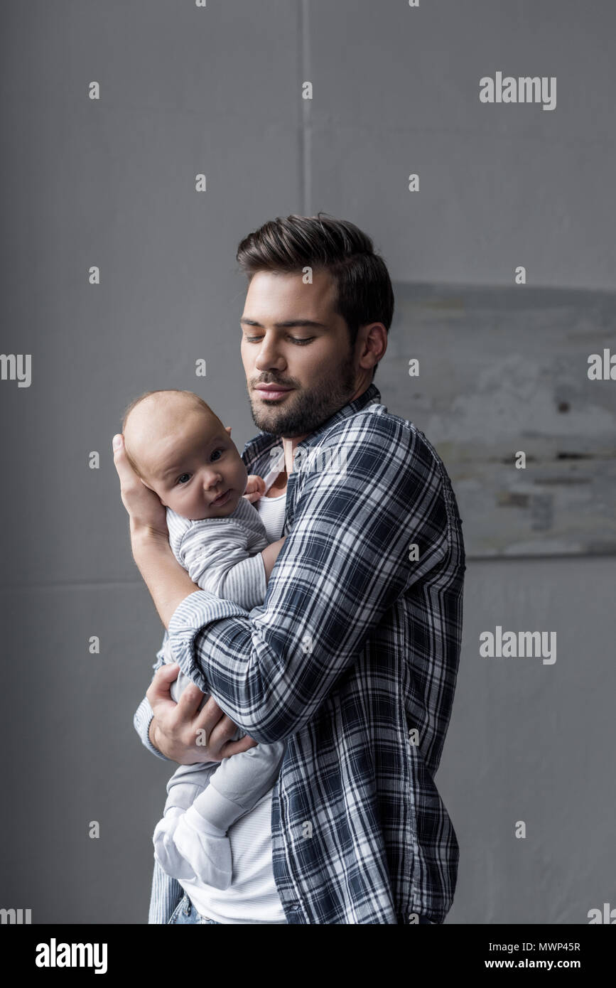 handsome father holding his cute newborn baby Stock Photo - Alamy