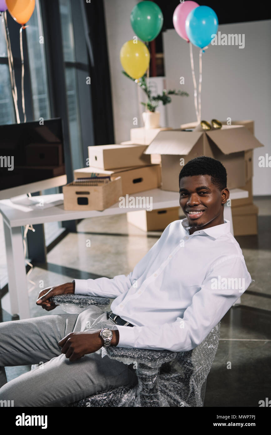 happy young african american businessman smiling at camera while ...