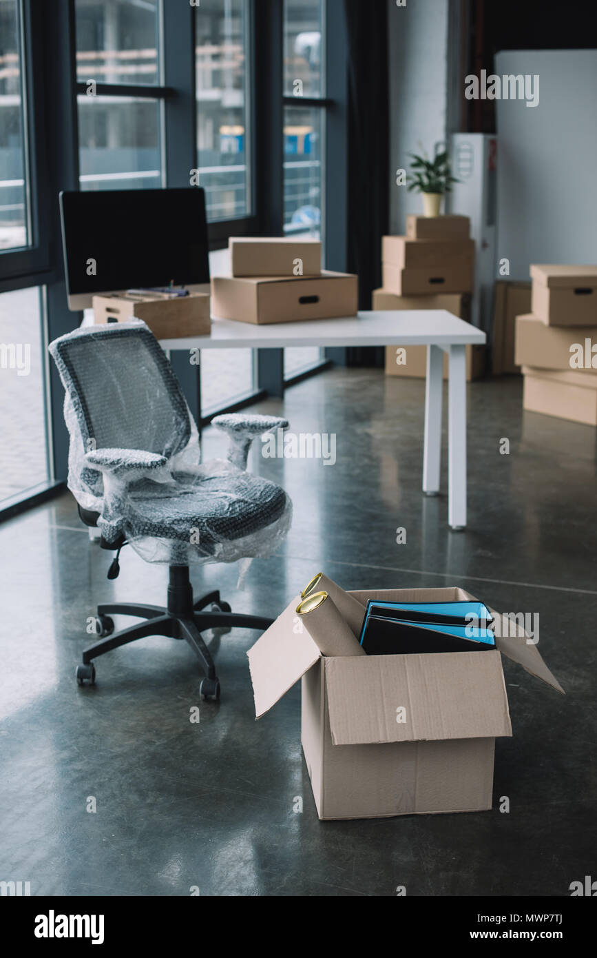 wrapped chair and cardboard boxes in office during relocation Stock ...
