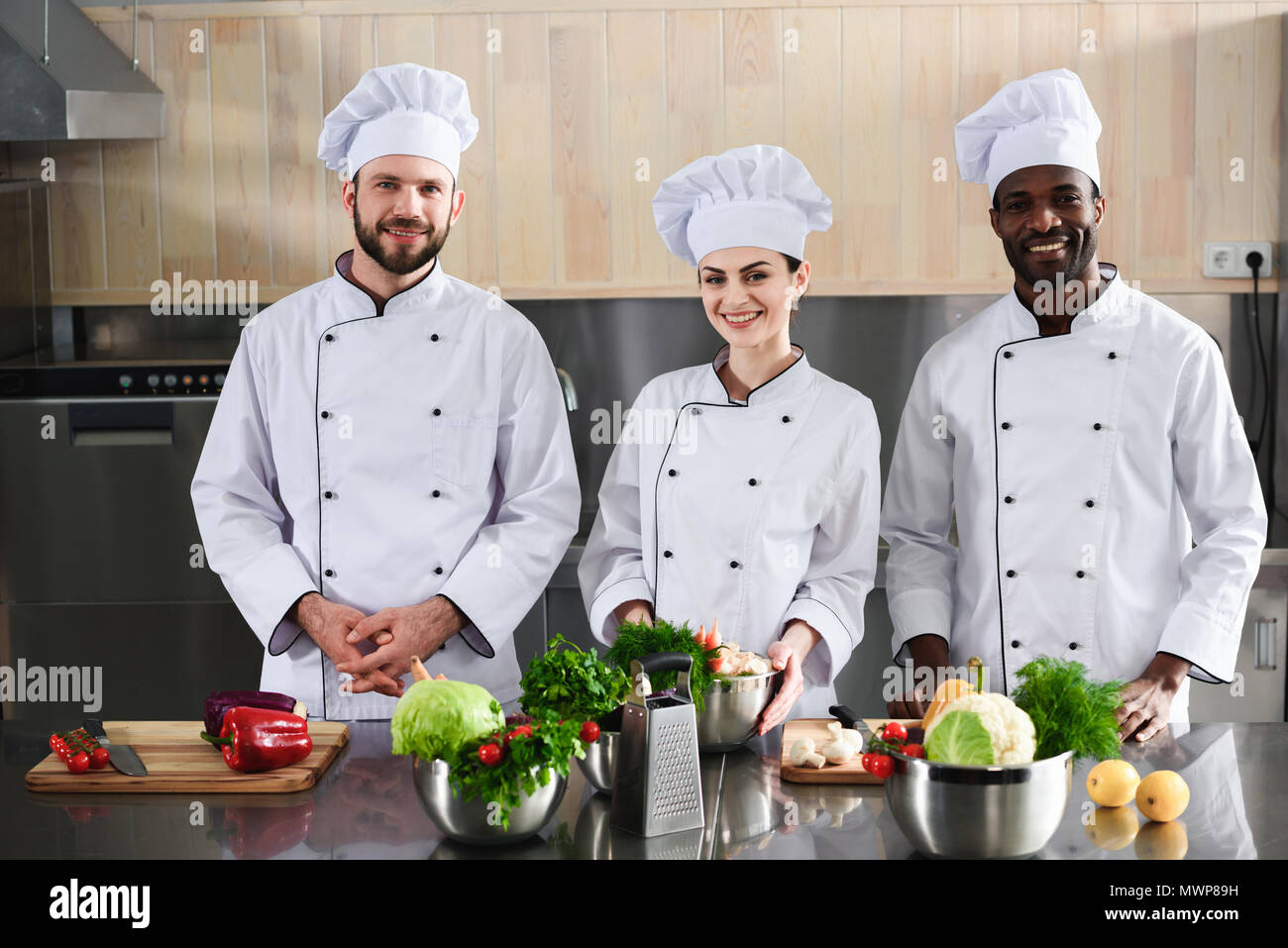 Multiracial chefs team smiling by modern kitchen counter Stock Photo ...