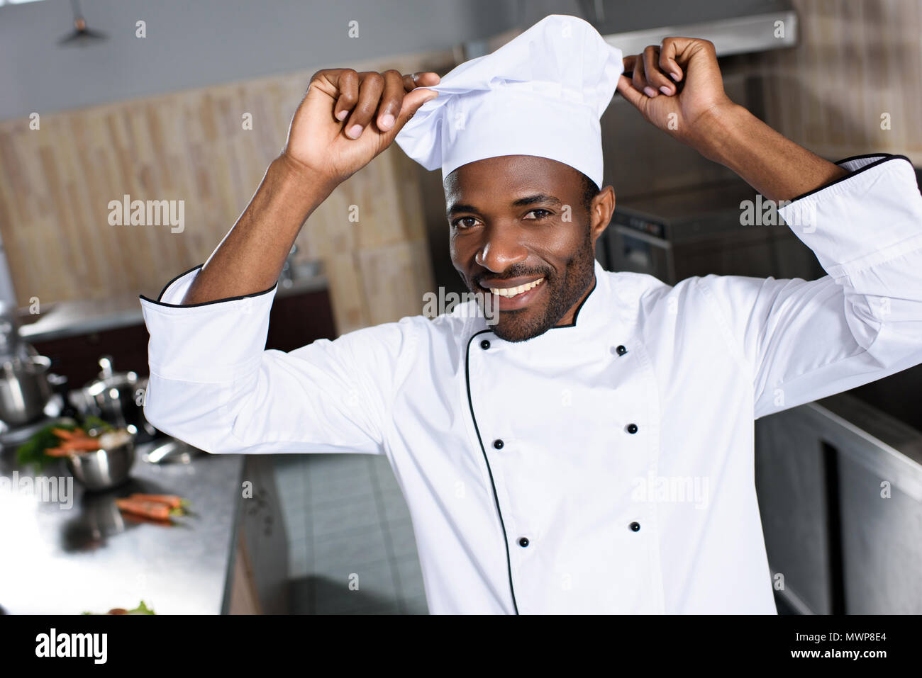 African american chef putting white toque on his head Stock Photo - Alamy