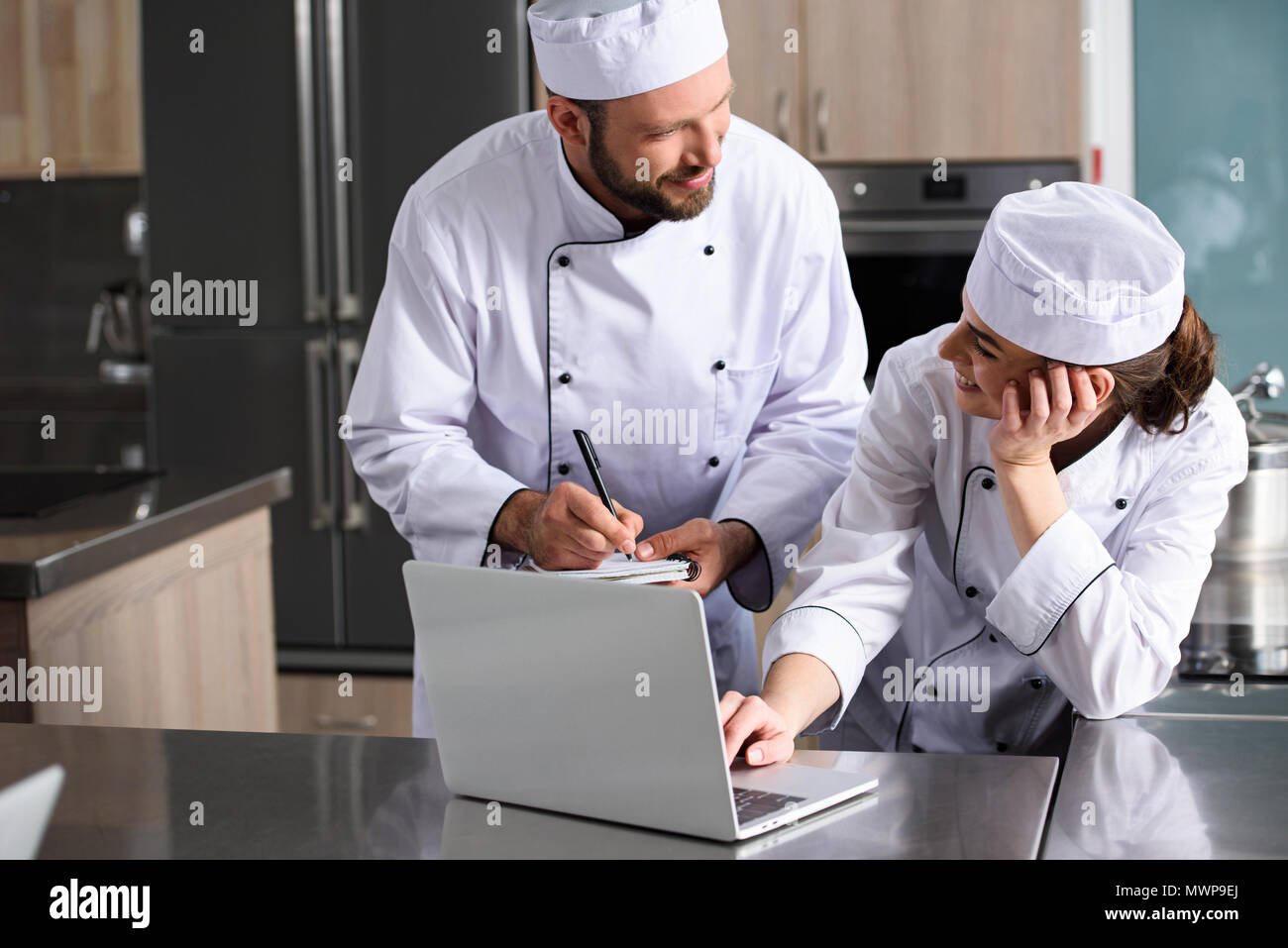 chefs using laptop at restaurant kitchen and searching recipe Stock ...