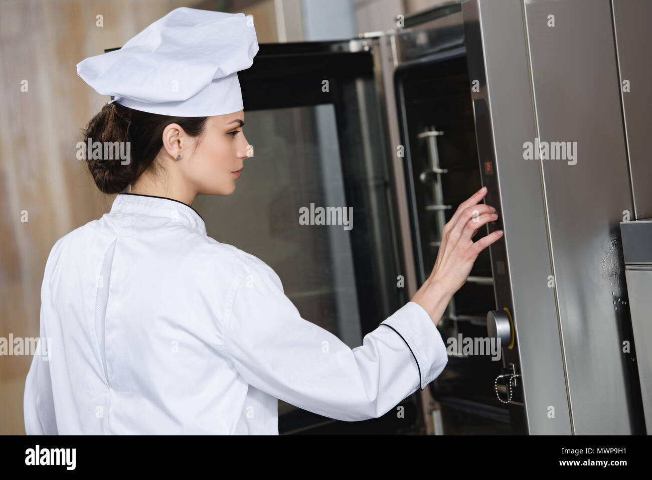 attractive chef setting oven for cooking at restaurant kitchen Stock ...