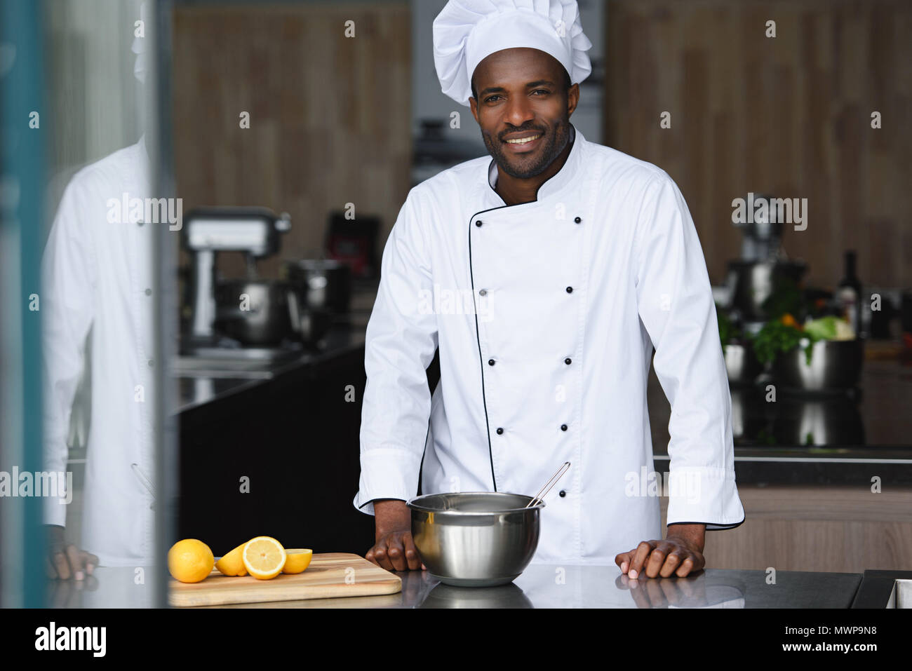 handsome african american chef standing near kitchen counter at ...
