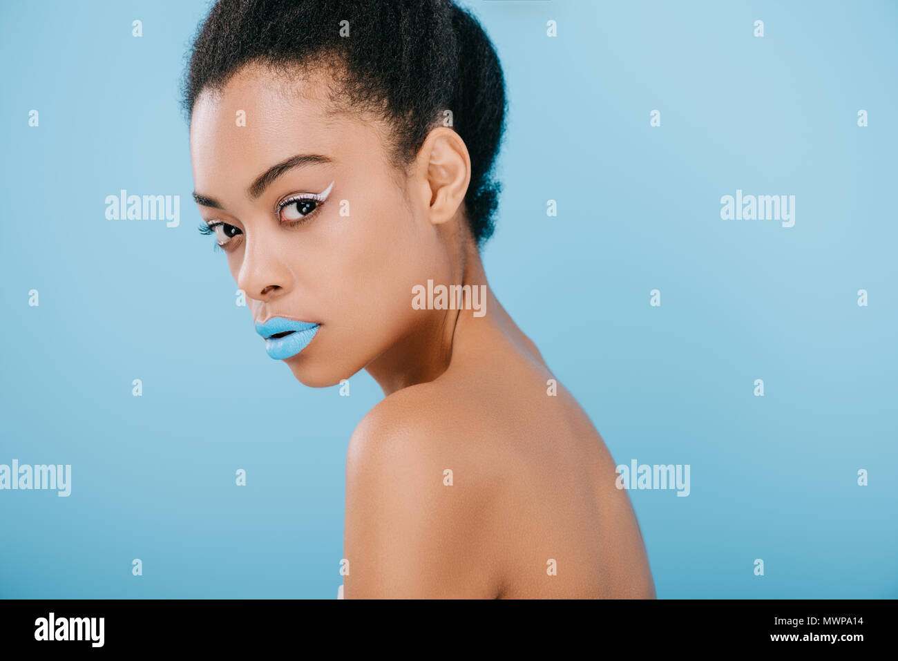 seductive young woman with creative makeup and blue lips looking at ...