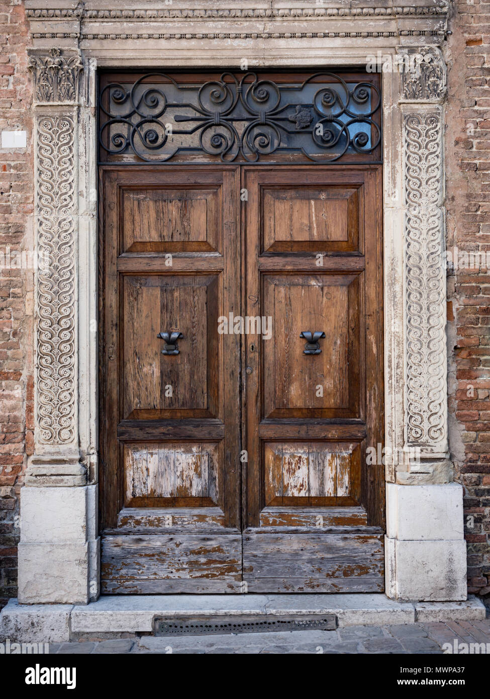 Old wooden portal with columns and architrave in white stone carved ...