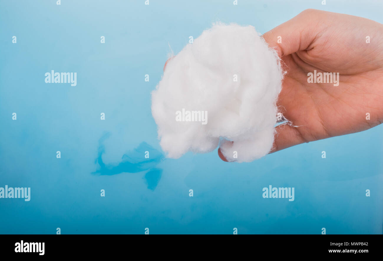 Hand holding some cotton in hand over blue water Stock Photo - Alamy