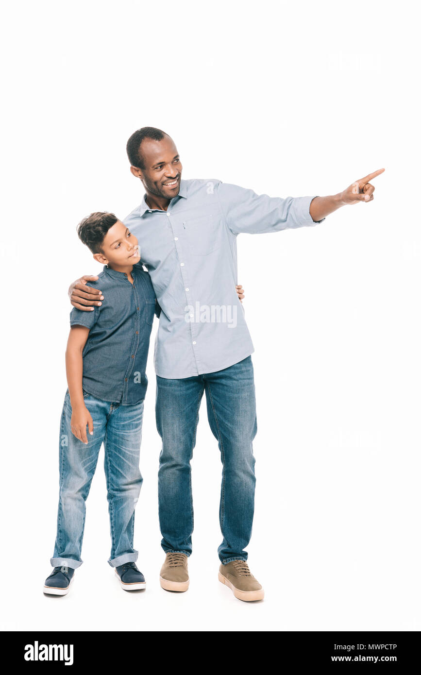 smiling african american father and son standing together and pointing ...