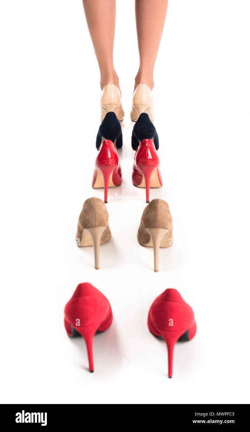 partial view of female legs and various stylish high heels isolated on ...