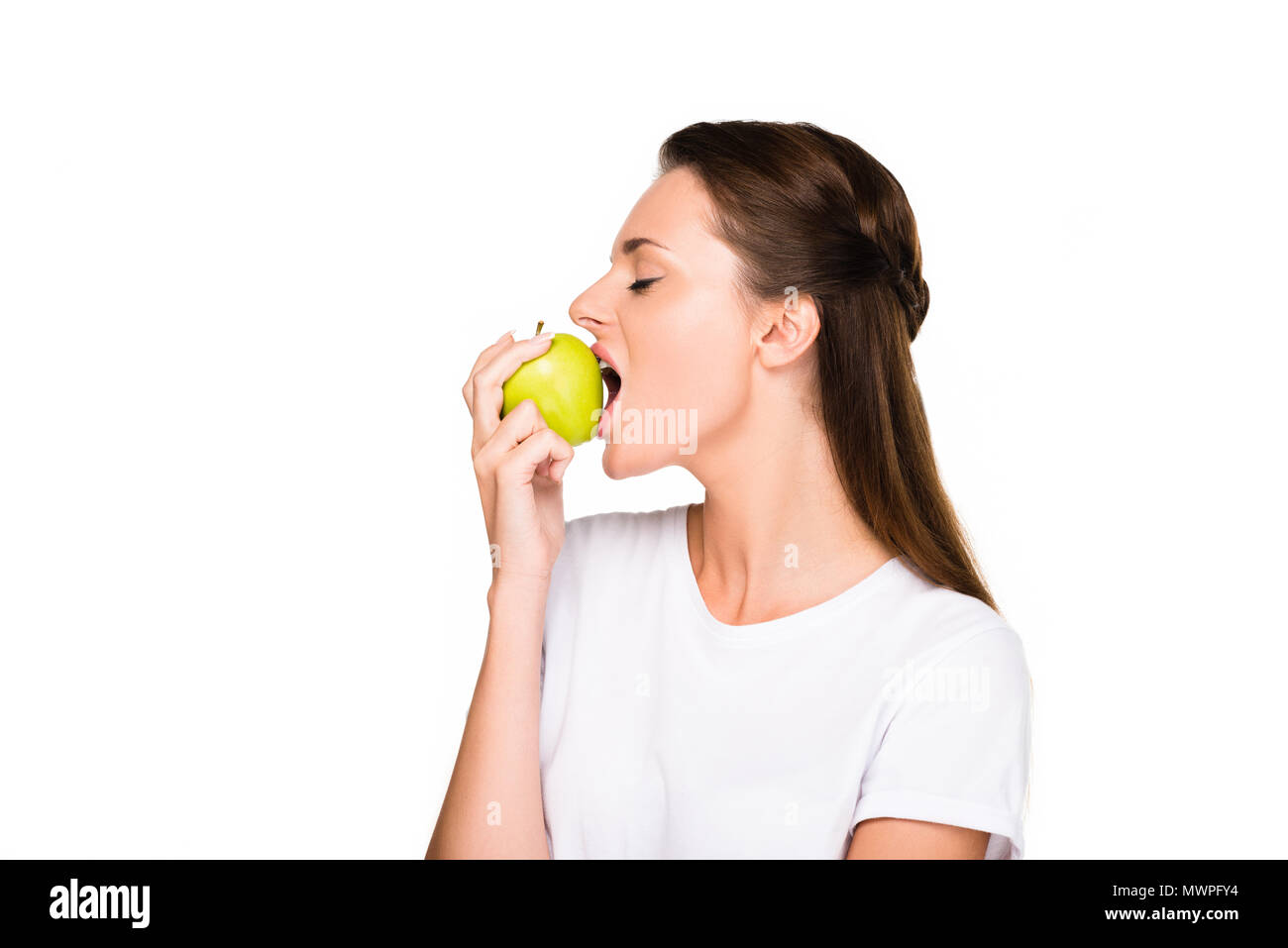 portrait of young woman biting fresh apple isolated on white Stock ...