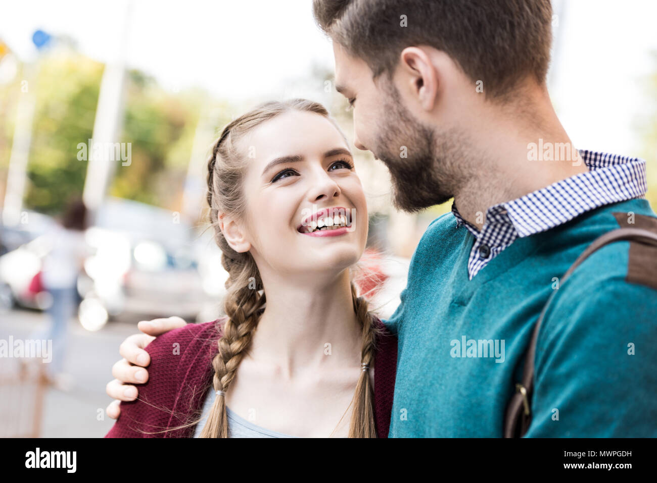 portrait of happy young couple in love looking at each other on street ...