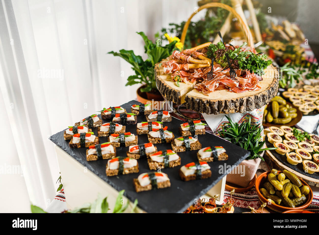table with different food snacks preparing for party Stock Photo - Alamy