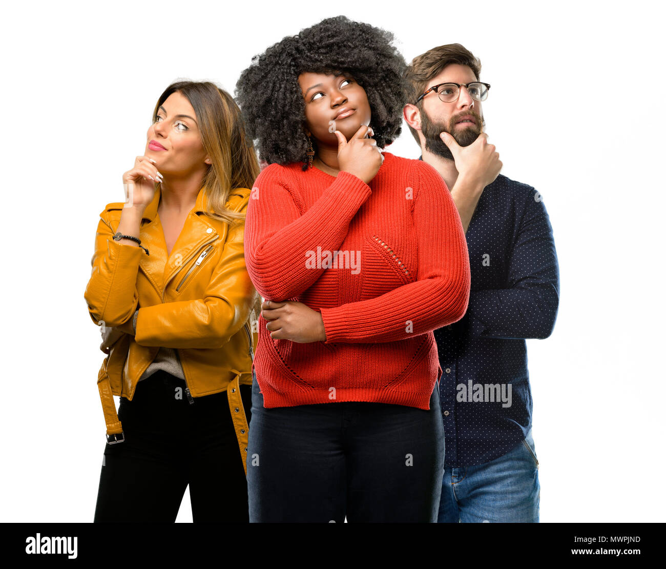 Group of three young men and women thinking and looking up expressing ...