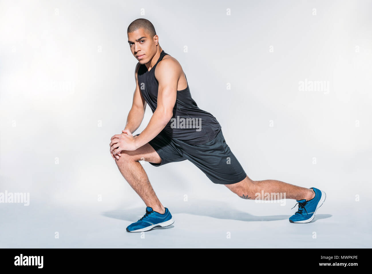 african american sportsman stretching legs and looking at camera Stock ...
