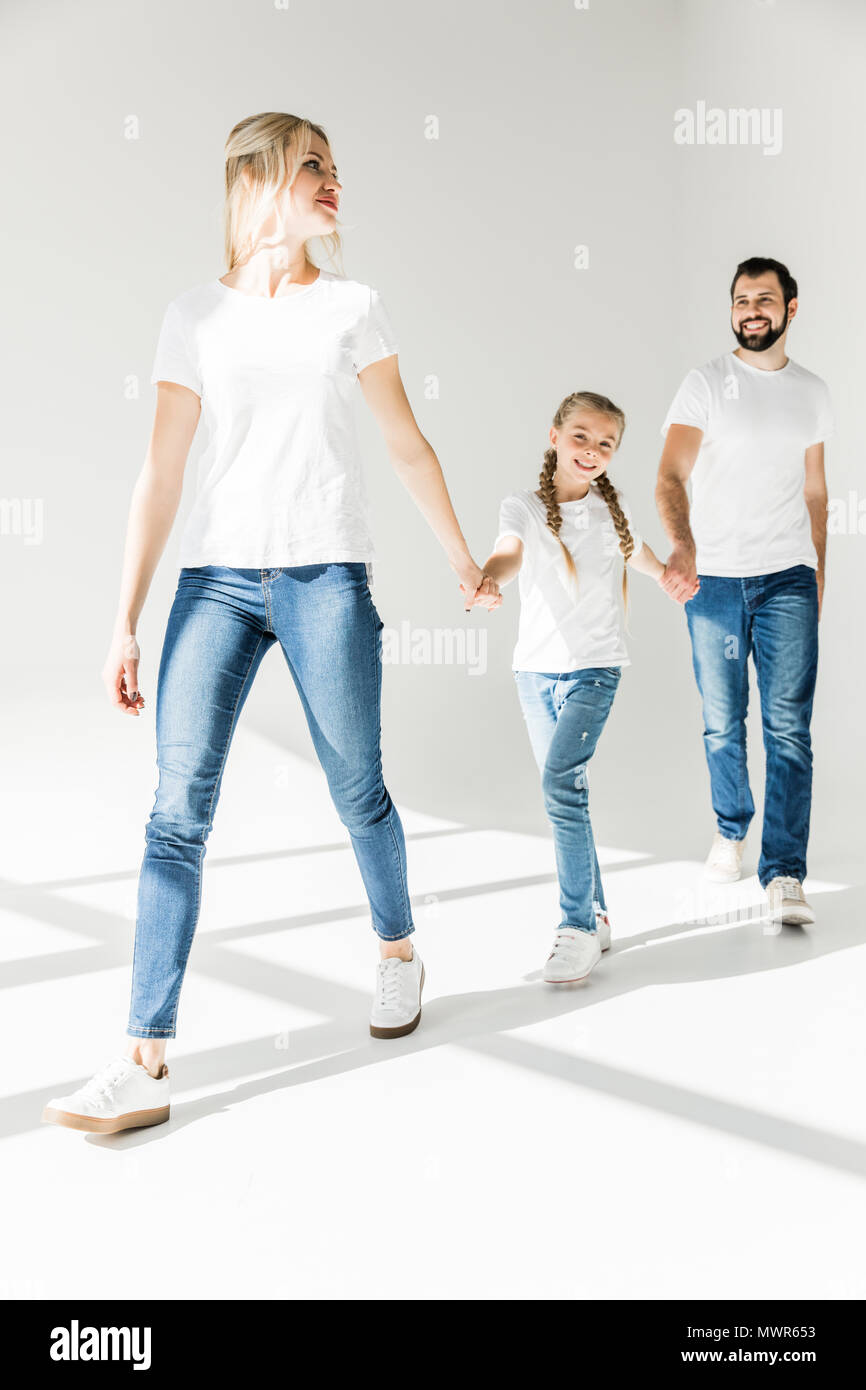 happy young family holding hands and walking together on white Stock Photo - Alamy