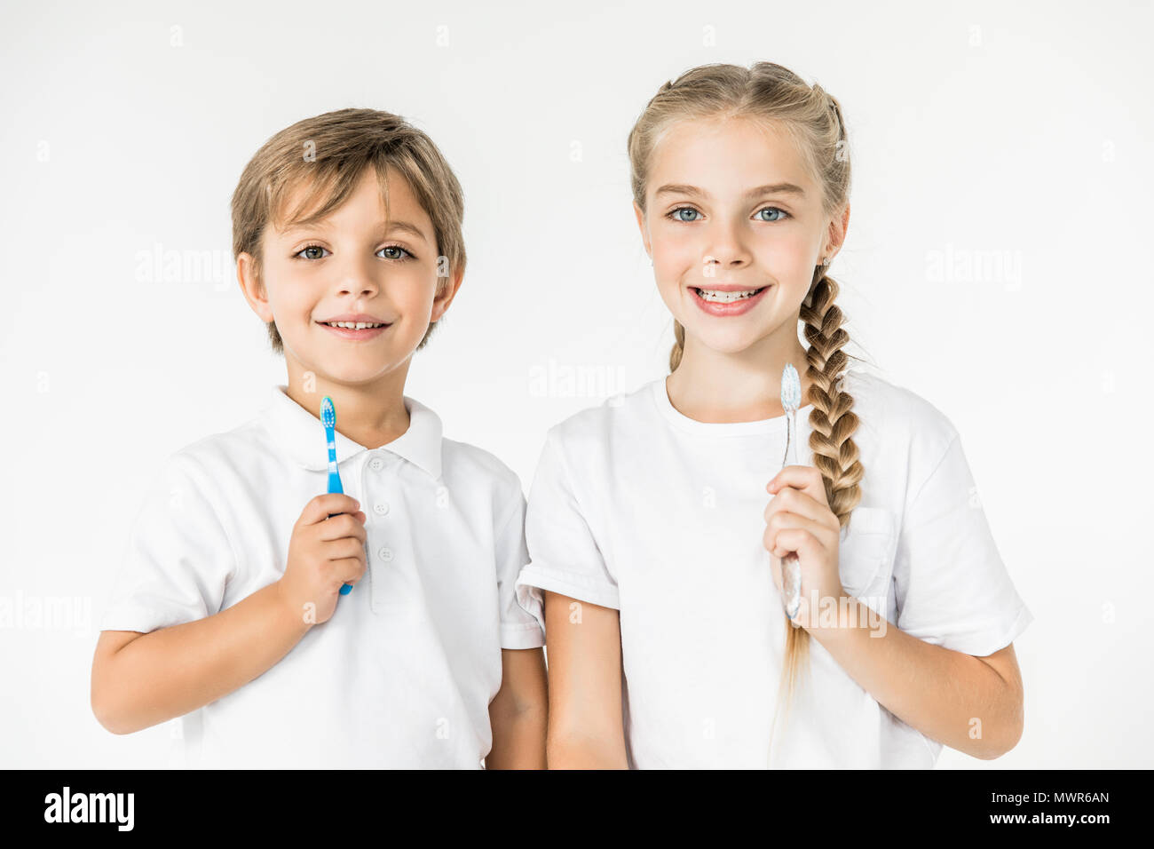 kids holding toothbrushes and smiling at camera isolated on white Stock ...
