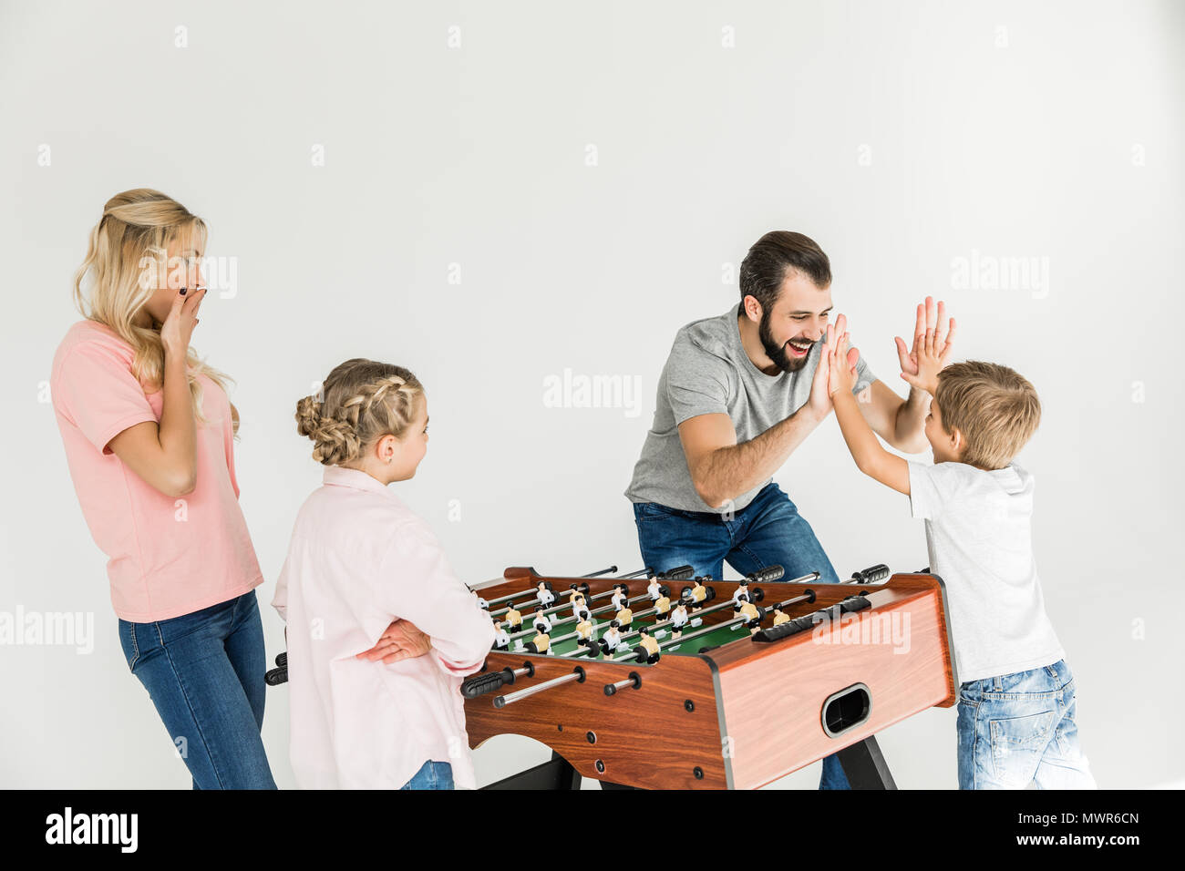 happy family with two kids playing foosball isolated on white Stock ...