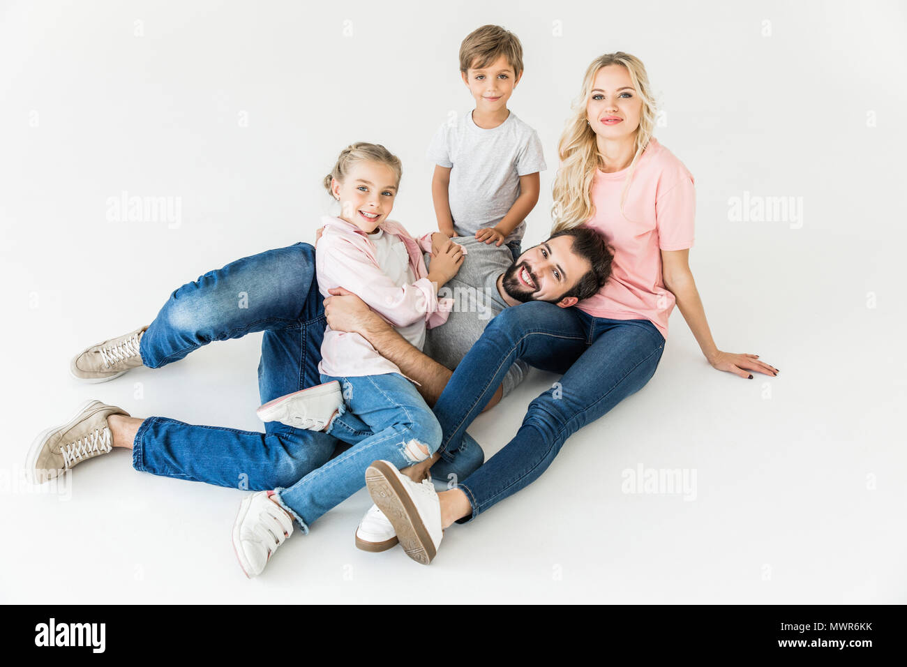 high angle view of happy young family with two kids smiling at camera ...