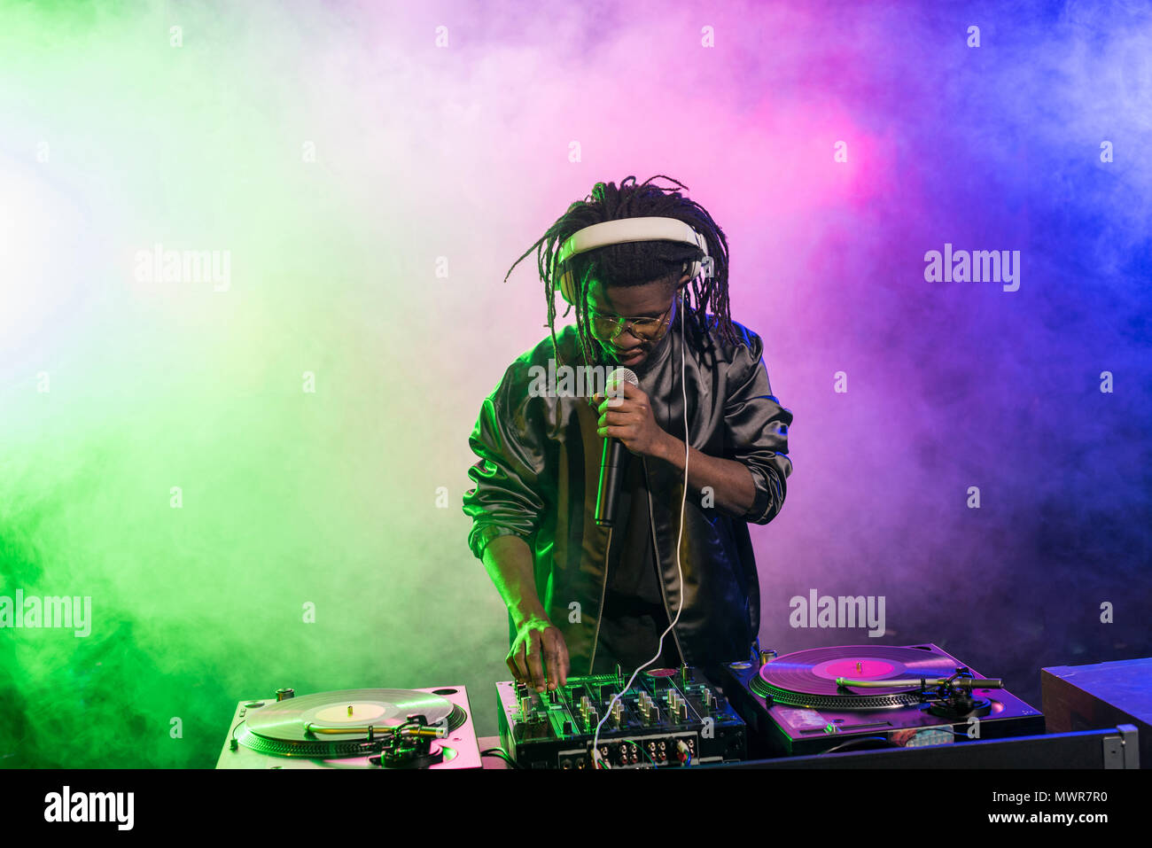 professional african american DJ in headphones with sound mixer in ...