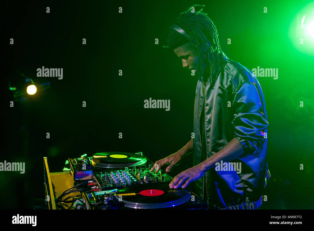 professional african american club DJ in headphones with sound mixer in ...