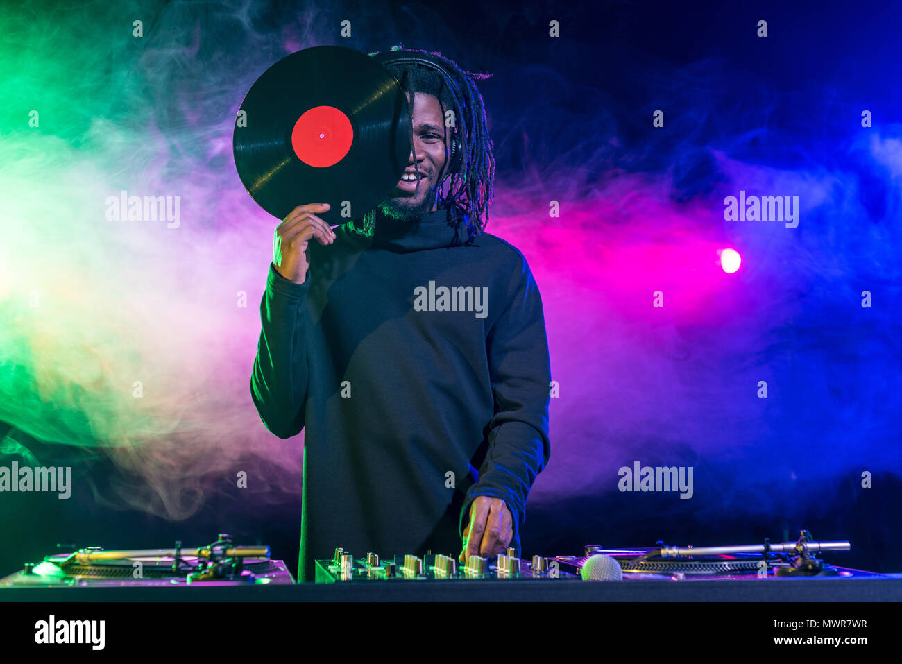 professional african american DJ with sound mixer and vinyl in ...