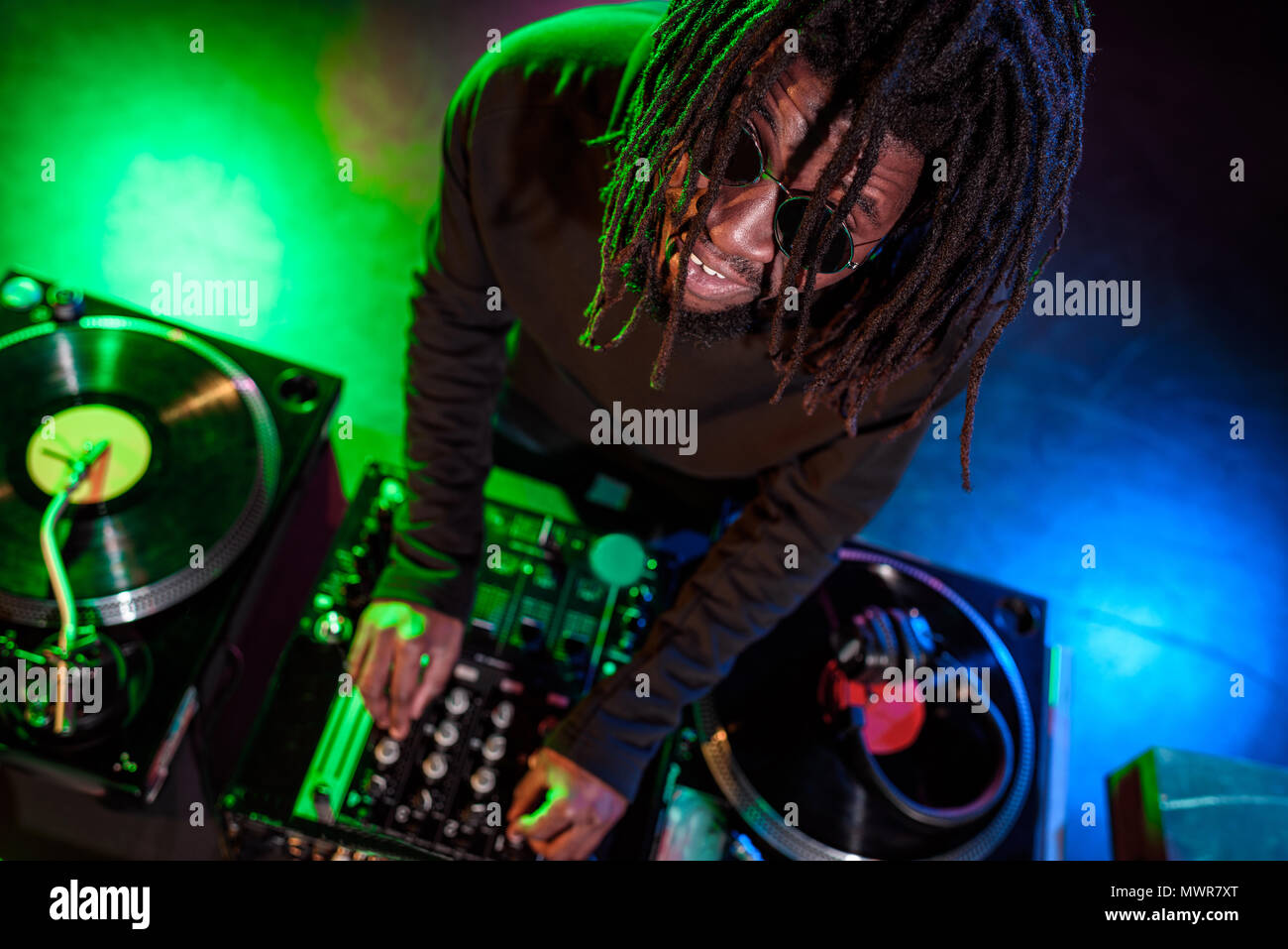 professional african american DJ with sound mixer in nightclub Stock ...