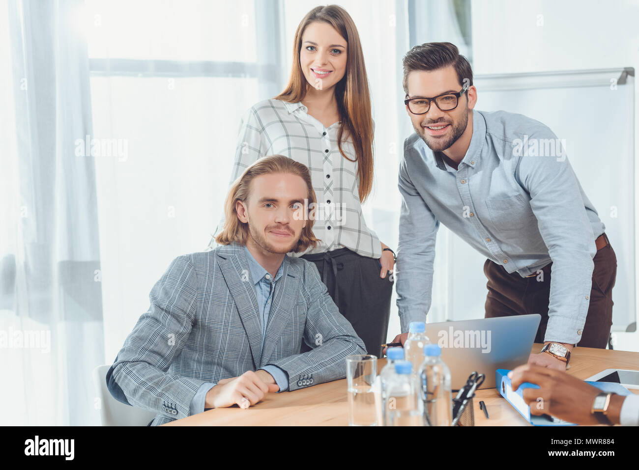 business team looking at camera at office space Stock Photo - Alamy