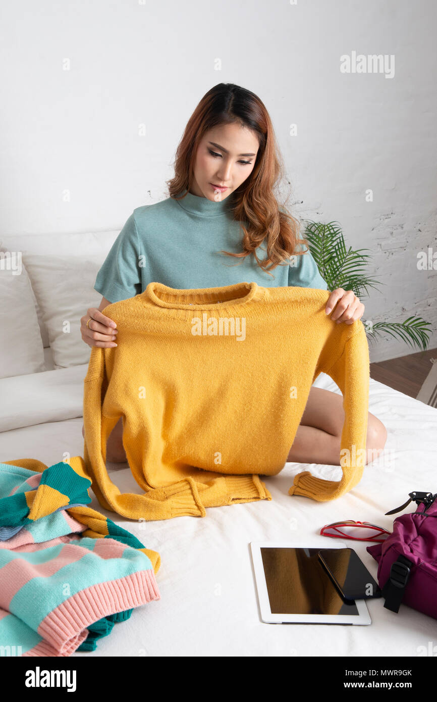 Woman packing her clothes for journey on bed Stock Photo - Alamy