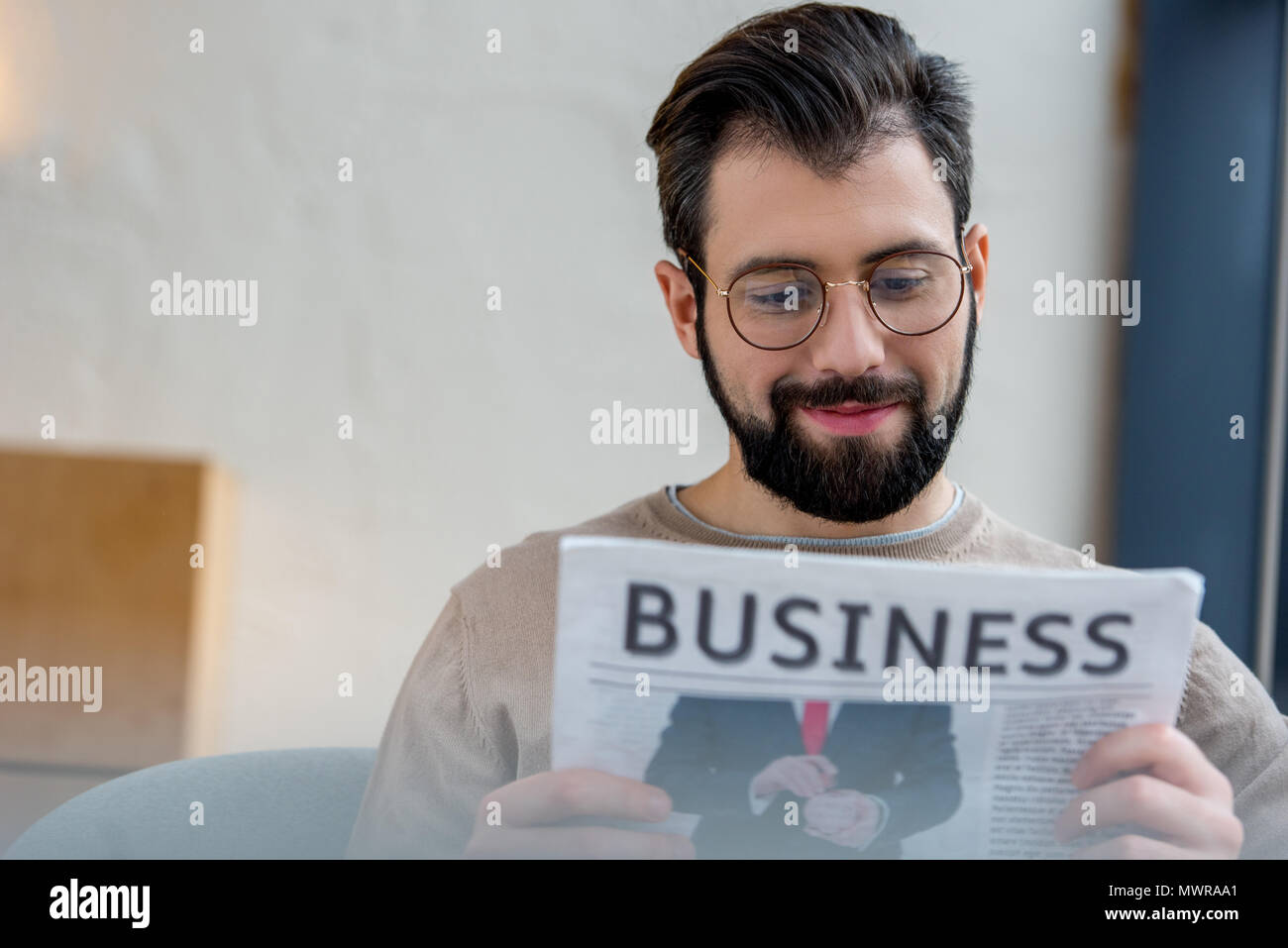 Smiling man reading business newspaper Stock Photo - Alamy