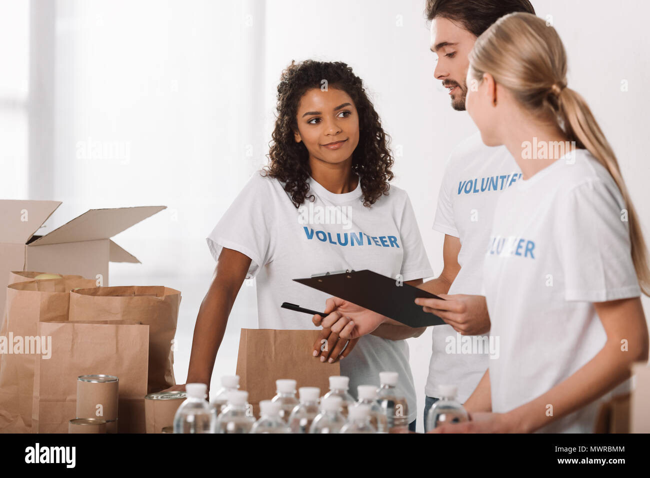 group of happy multiethnic volunteers working together Stock Photo - Alamy