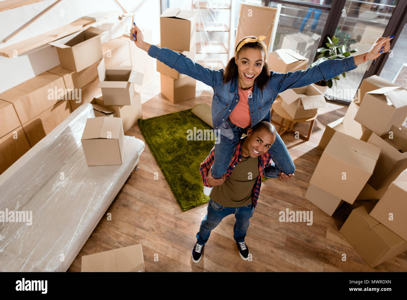 excited african american girl sitting on shoulders of her boyfriend ...