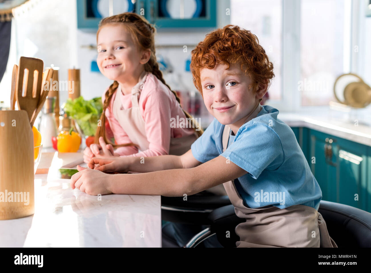 adorable happy children smiling at camera while cooking together in ...