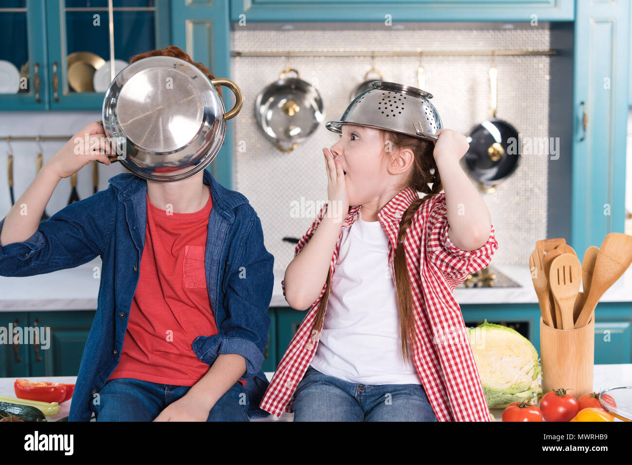 adorable little children having fun with utensils while sitting on ...