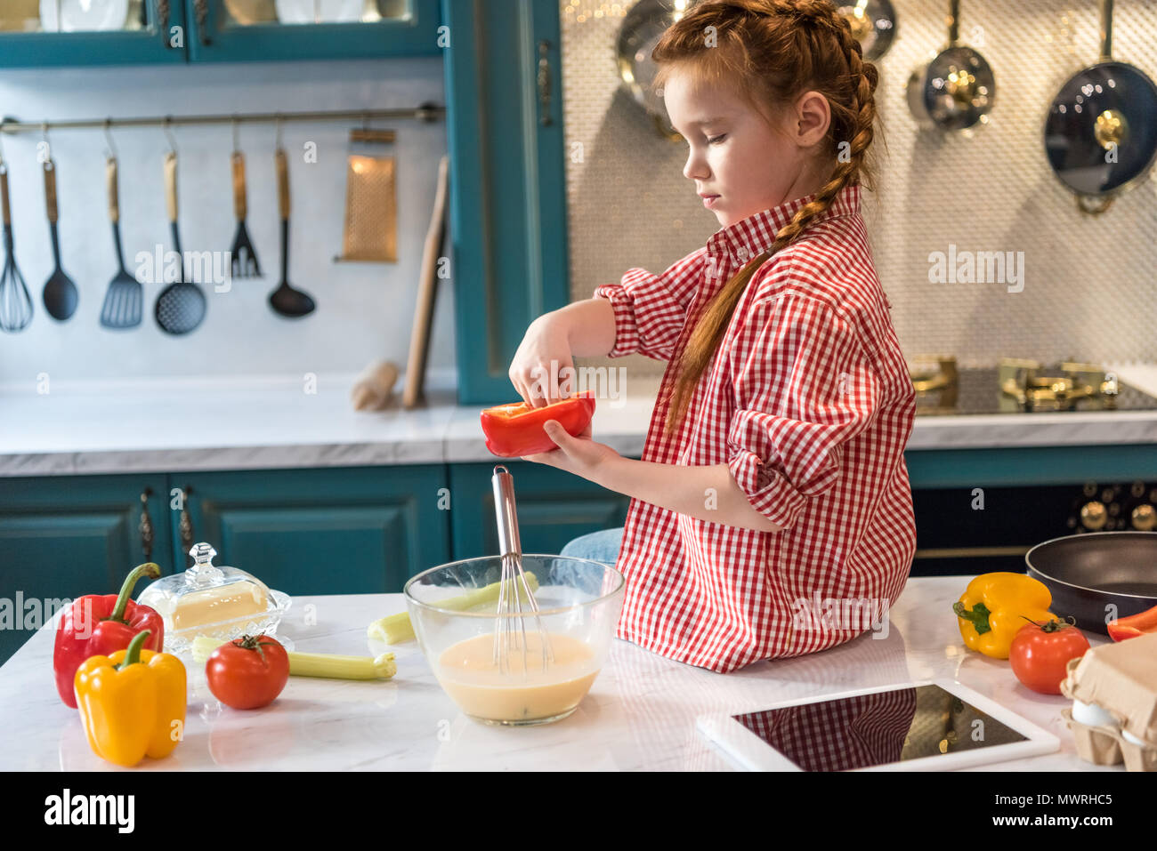 adorable little child cooking while sitting on kitchen table Stock ...