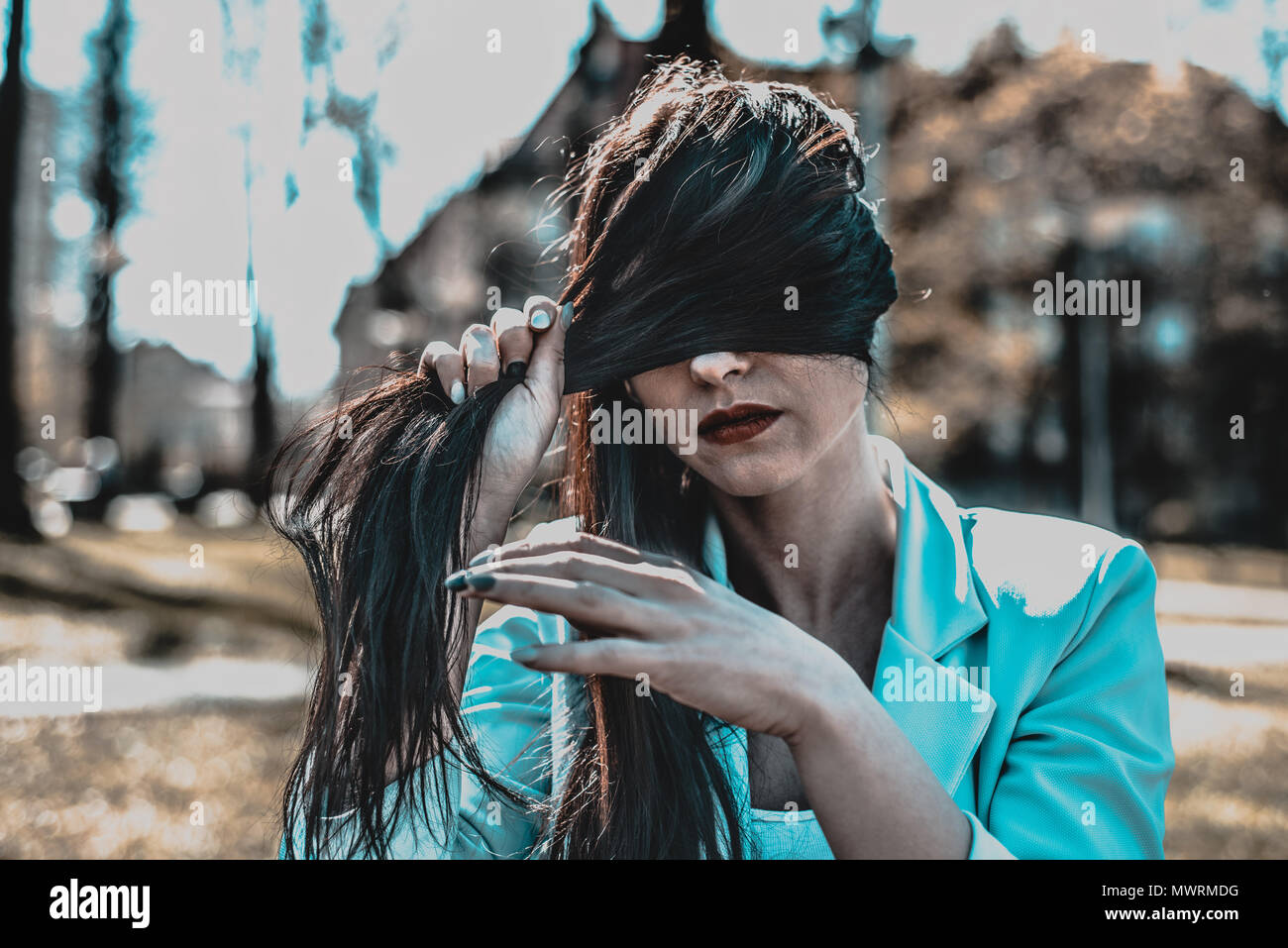 A nostalgic portrait of women sitting on a bench and covering her face ...