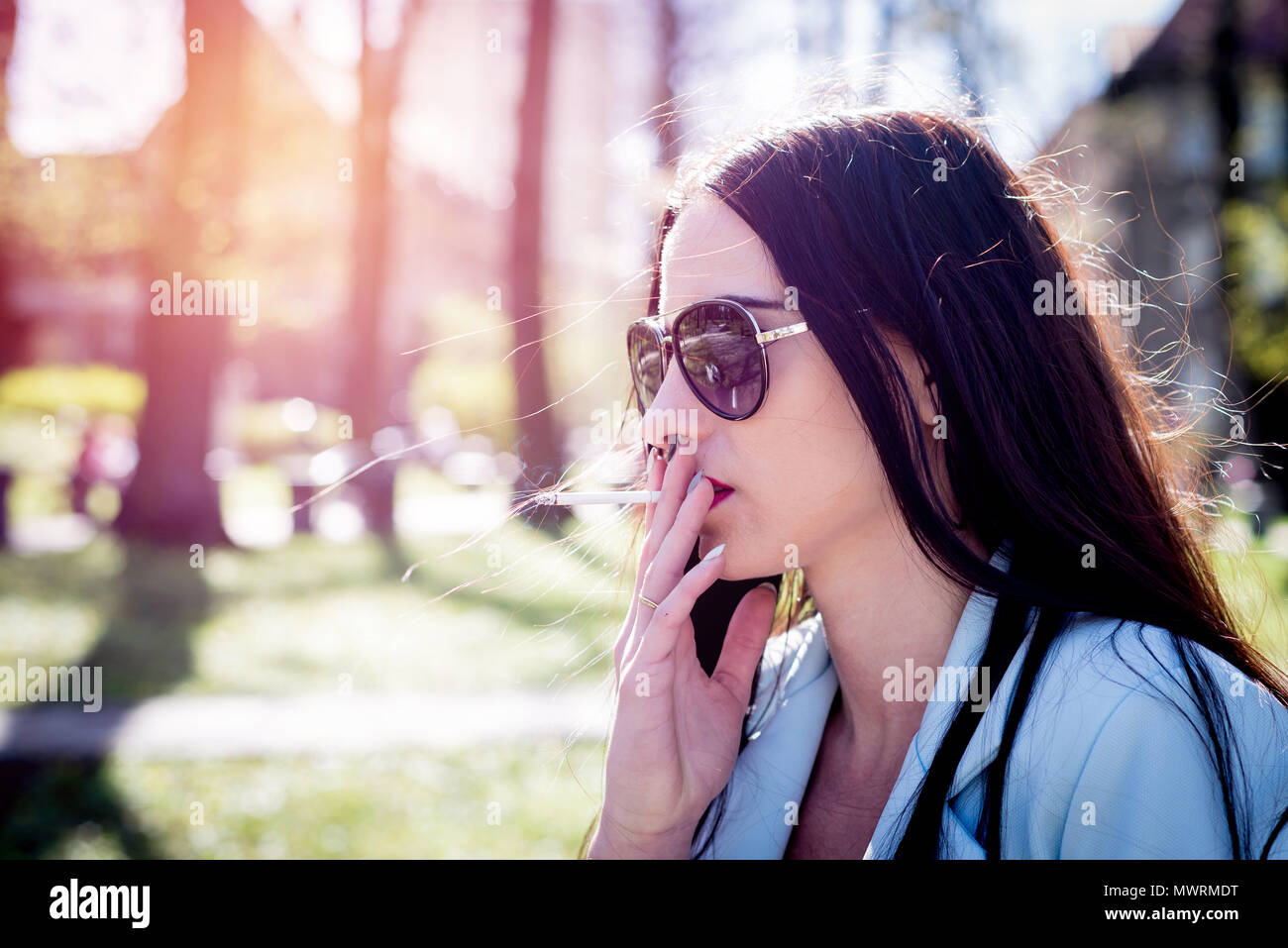 Closeup Of A Womans Face Smoking A Cigarette An Attractive Girl In Sunglasses Holds A