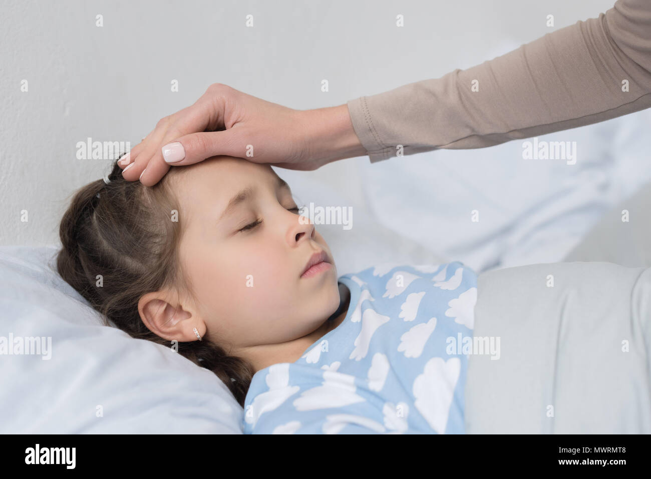 Mother touching daughters forehead with hand to feel a fever Stock ...