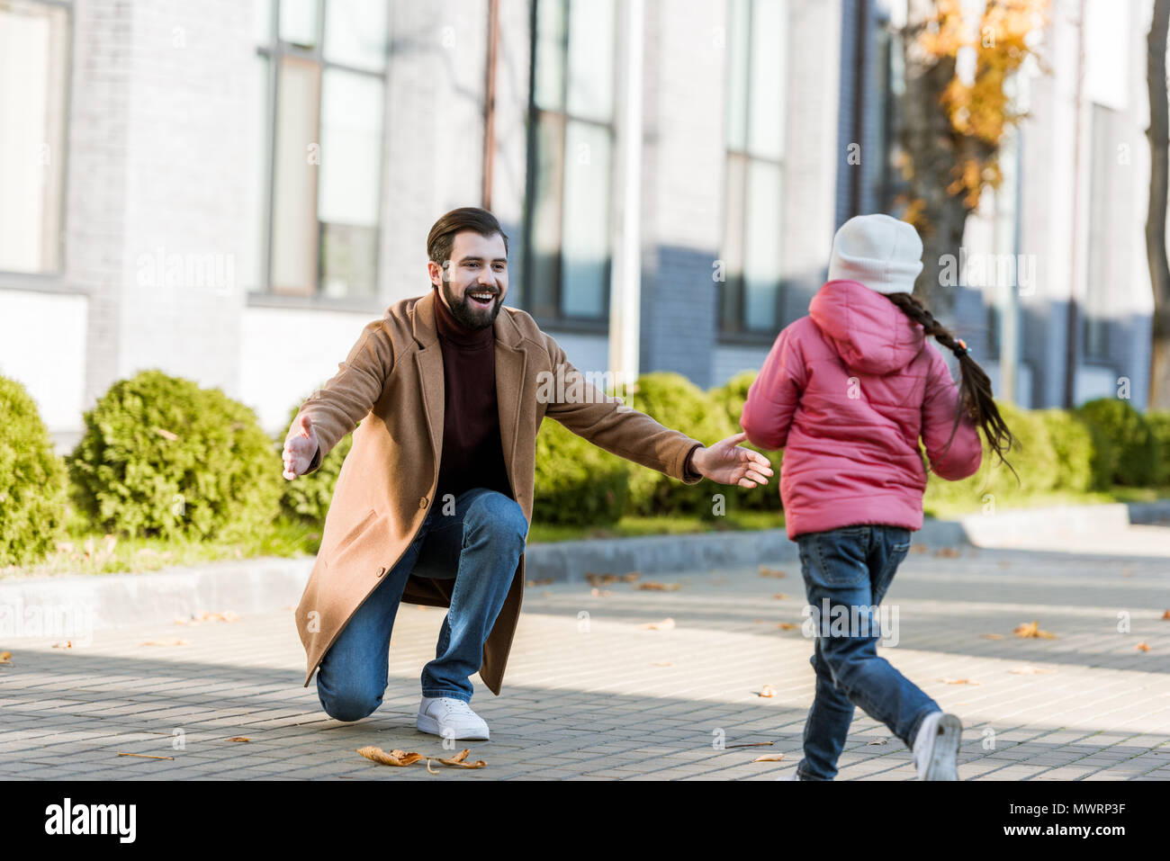 little daughter running to hug her happy father. outside Stock Photo ...