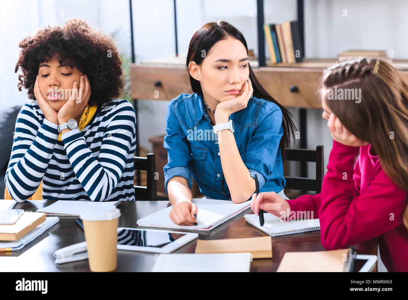 tired multiracial students doing homework together Stock Photo - Alamy