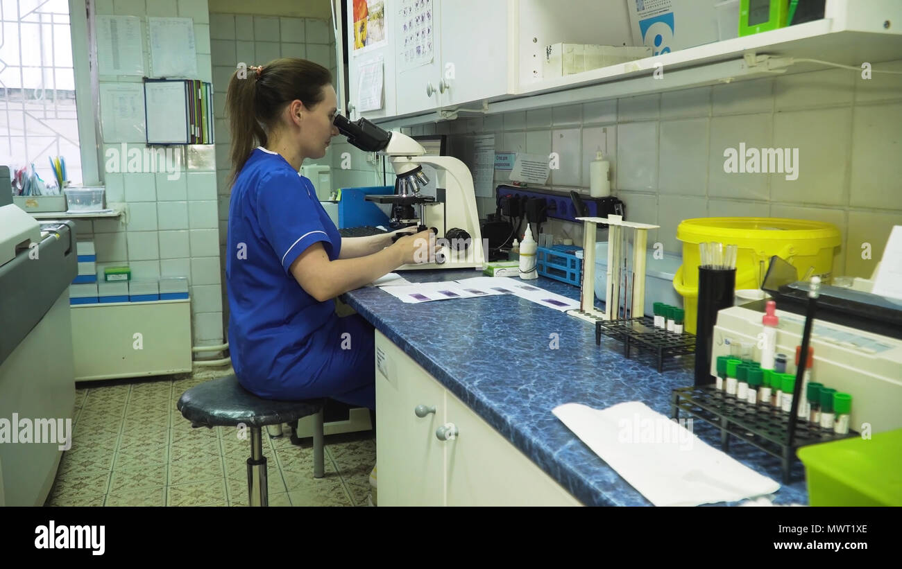 Woman lab assistant working with a microscope in Laboratory. Female ...