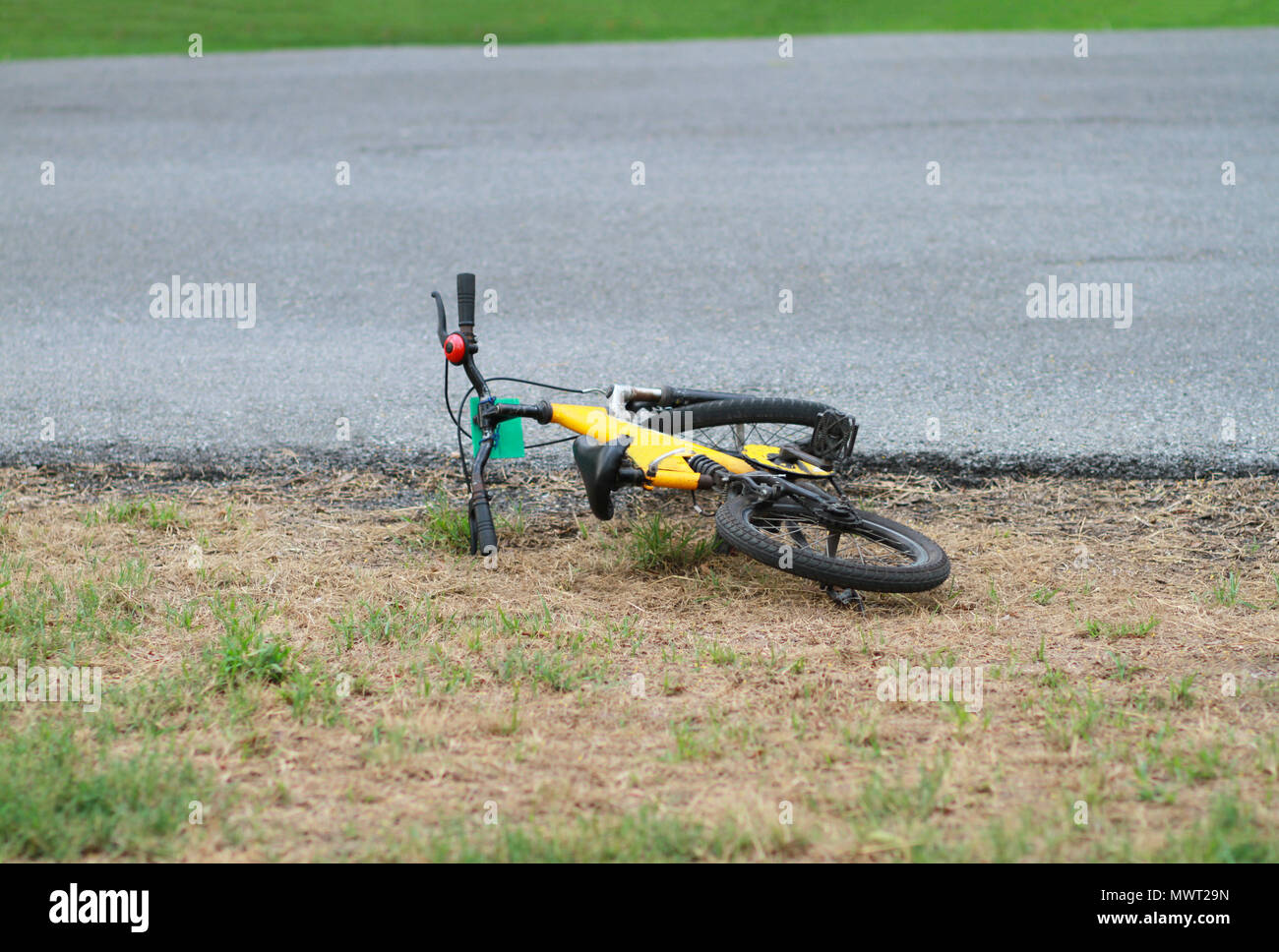 Yellow bike fell off beside the street Stock Photo - Alamy