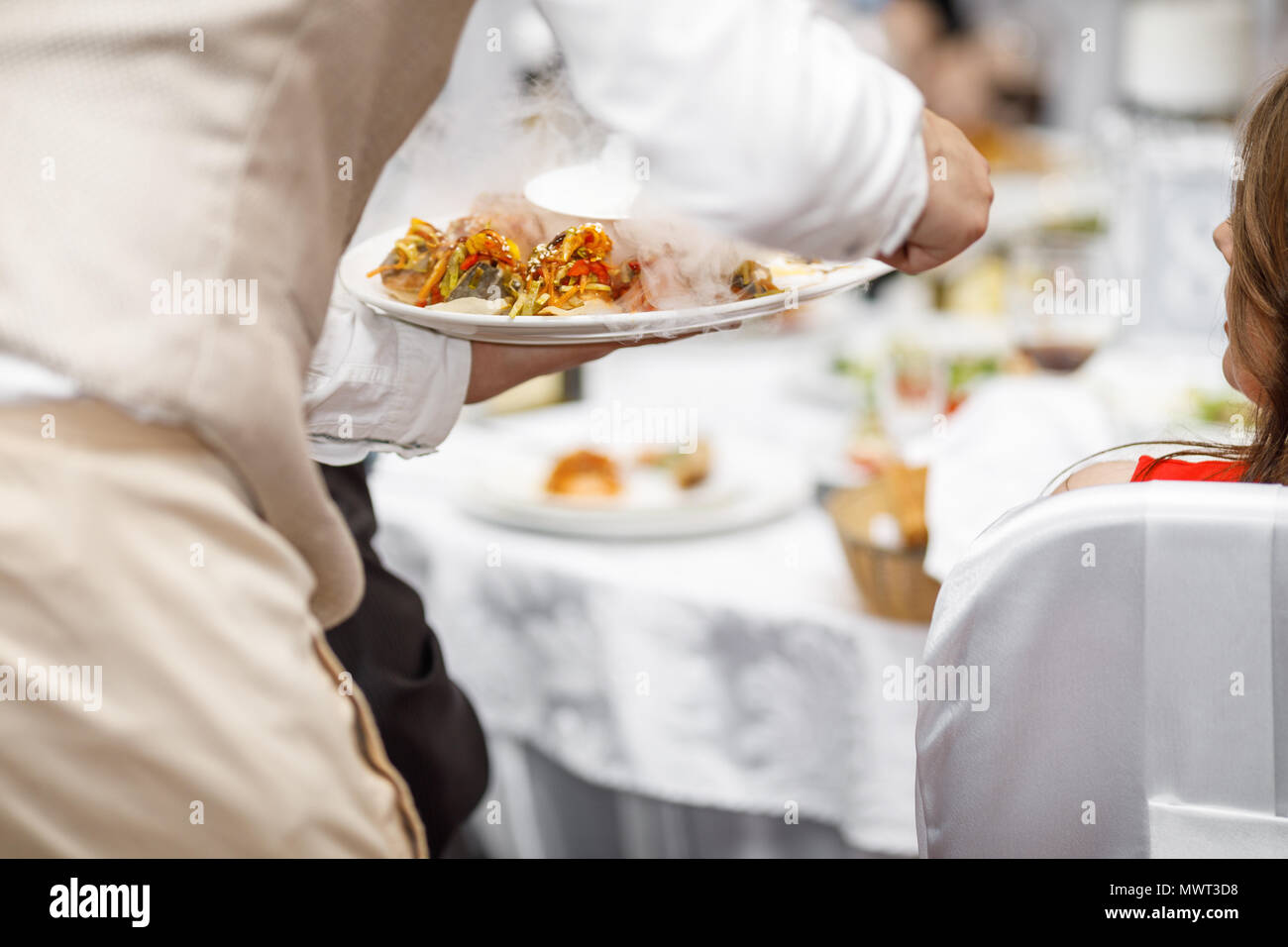 Waiters carrying plates with meat dish at a wedding Stock Photo - Alamy