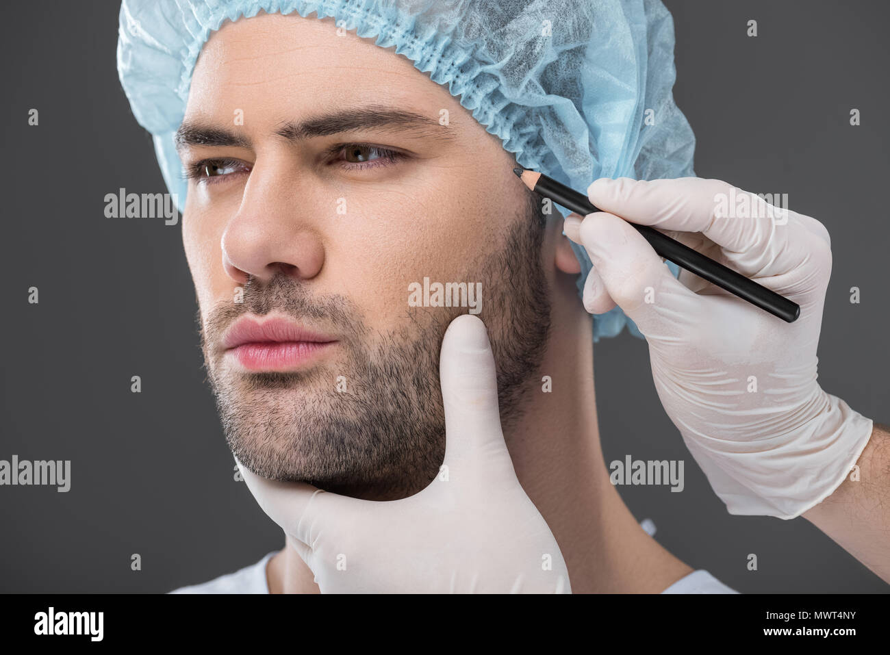 doctor drawing lines for facelifting on man, isolated on grey Stock ...