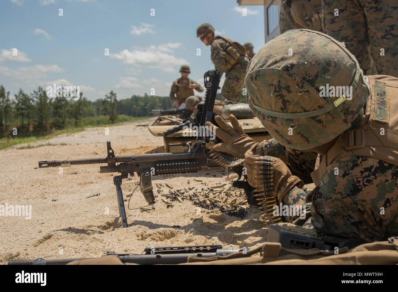 A Marine places rounds on the feed tray of an M249 light machine gun ...