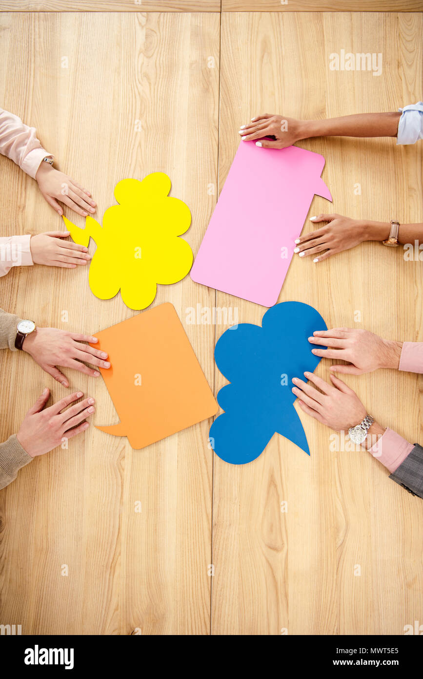 overhead view of multiracial business people at wooden table with empty ...