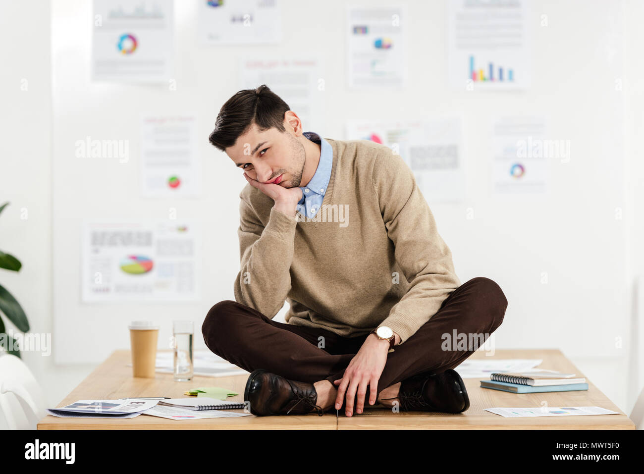 Bored young businessman sitting table hi-res stock photography and ...