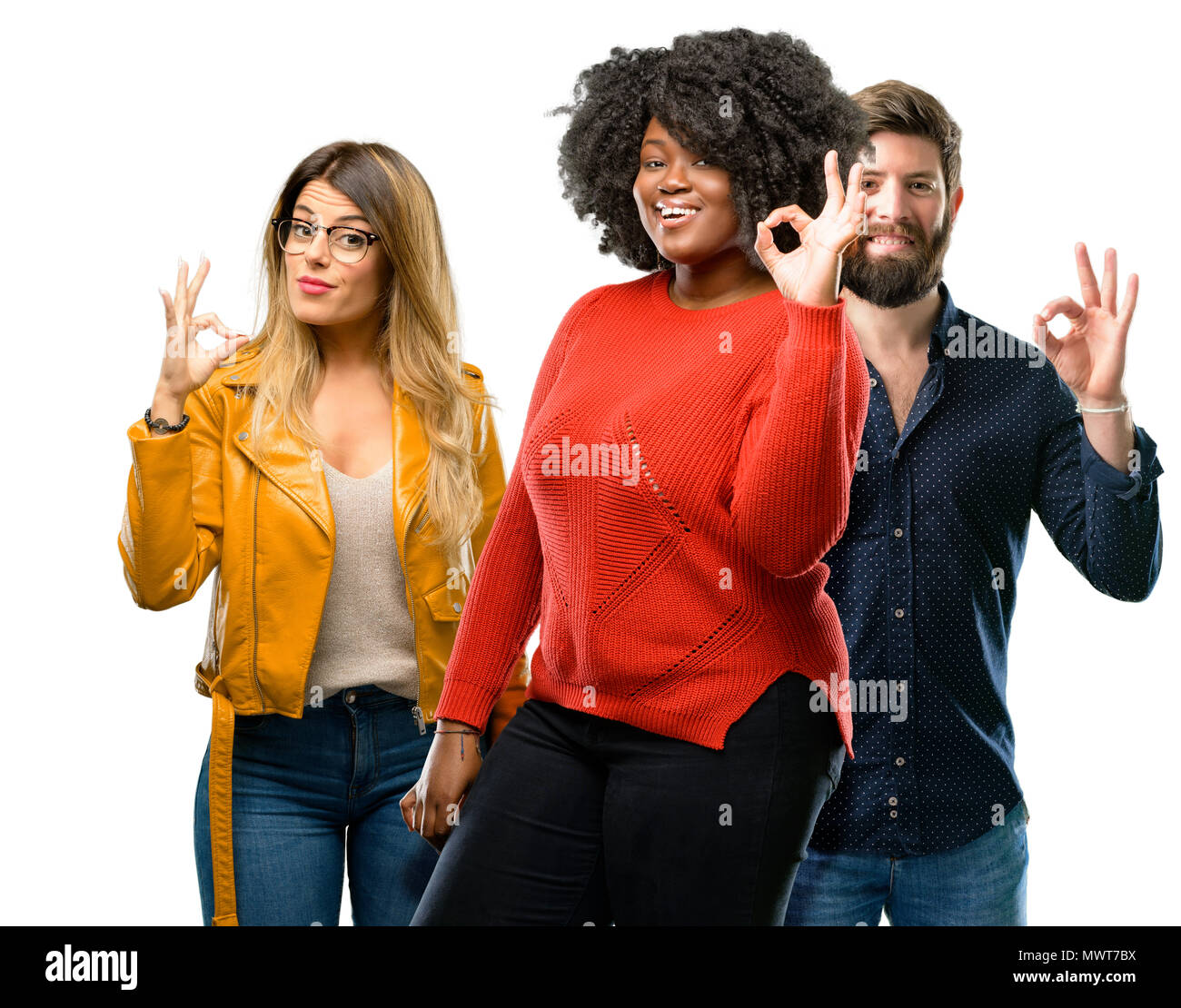 Group of three young men and women doing ok sign with hand, approve ...