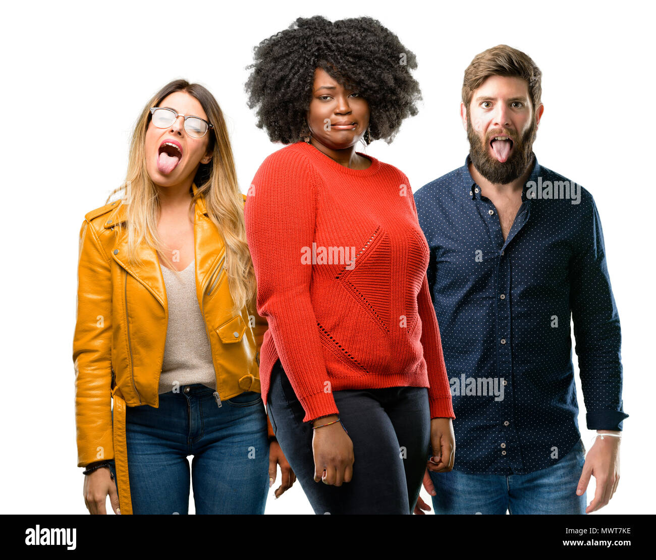 Group of three young men and women feeling disgusted with tongue out ...