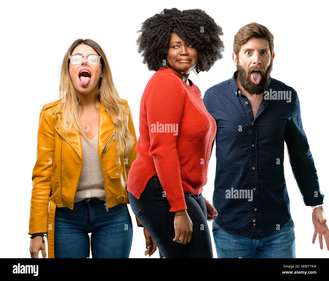 Group of three young men and women feeling disgusted with tongue out ...