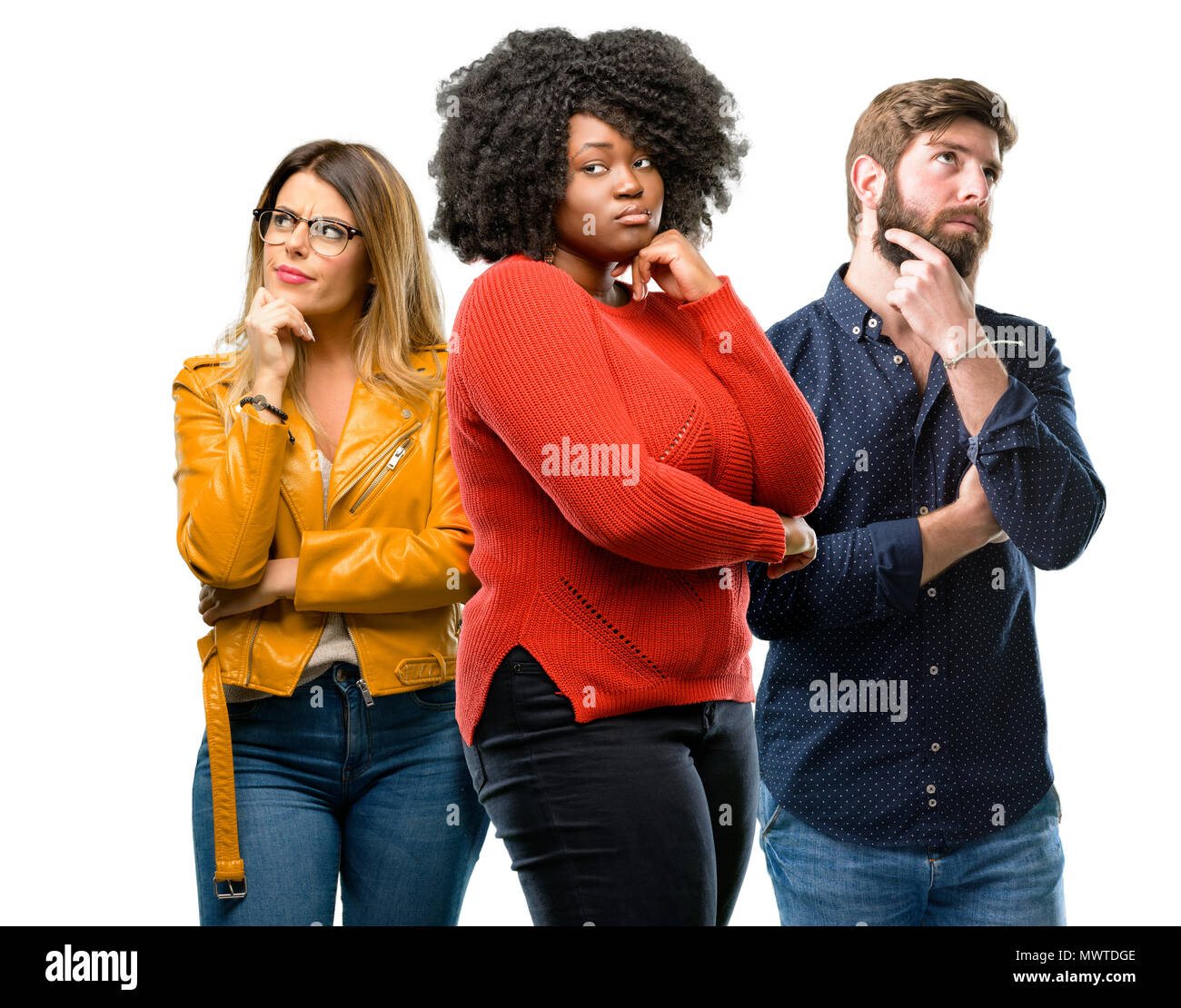 Group of three young men and women thinking and looking up expressing ...